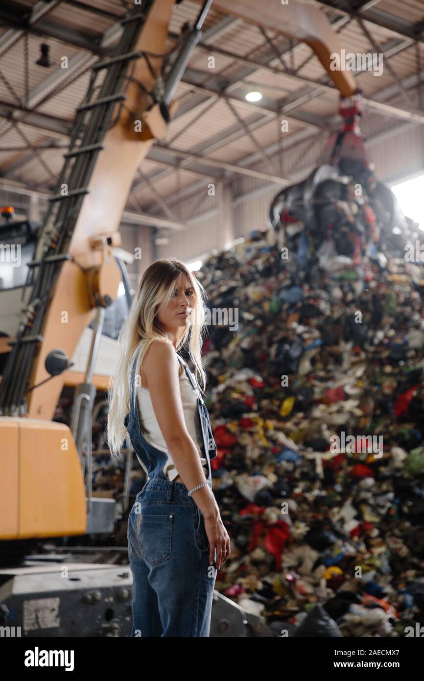 Nature pollution activist at a huge trash dump - Young blonde woman ...
