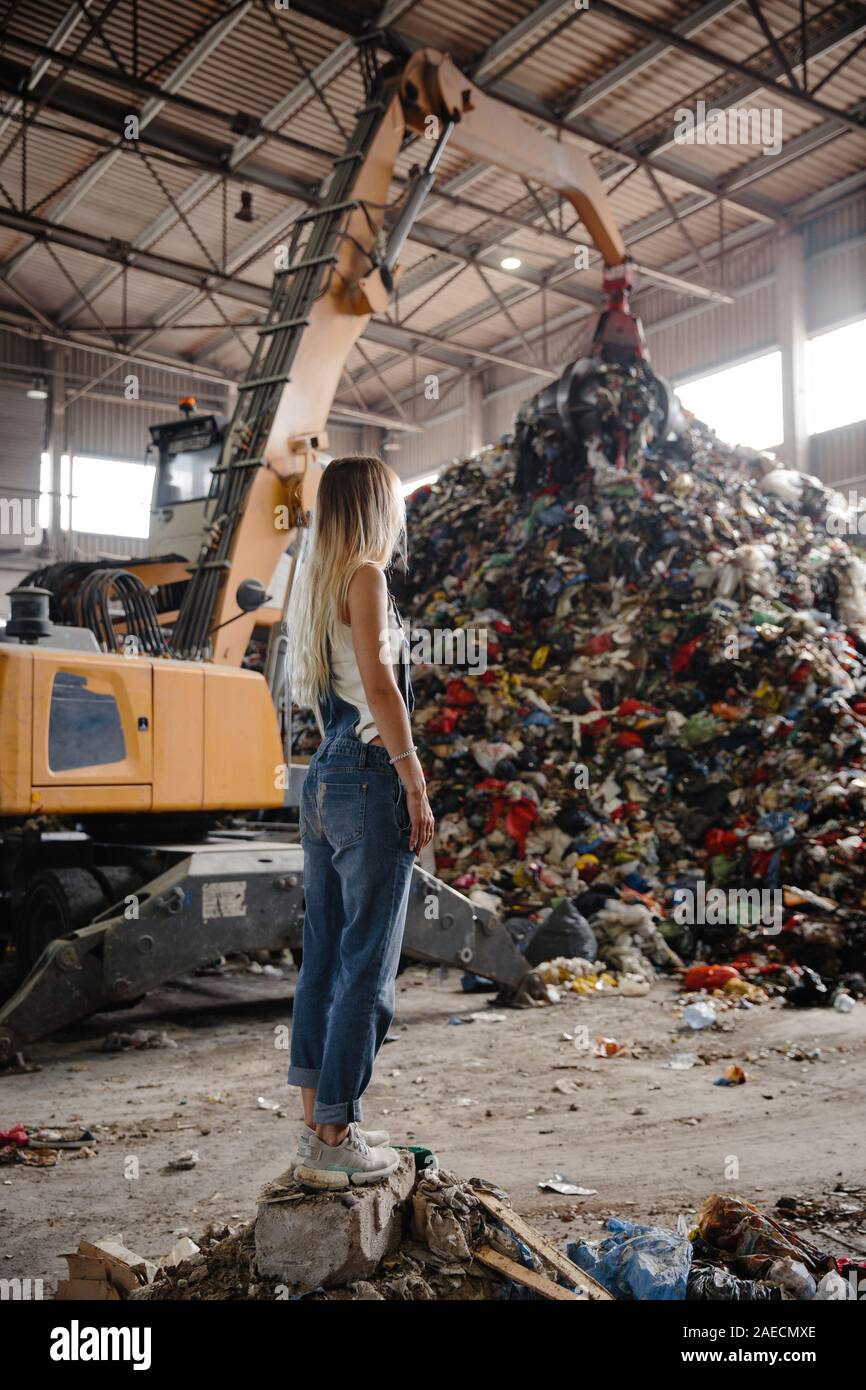 Nature pollution activist at a huge trash dump - Young blonde woman ...