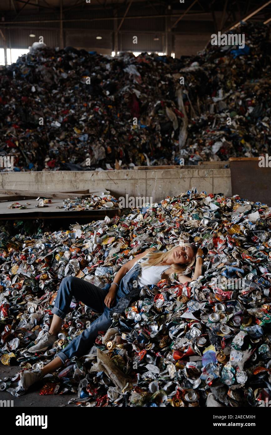 Laying down - Nature pollution activist at a huge trash dump - Young ...