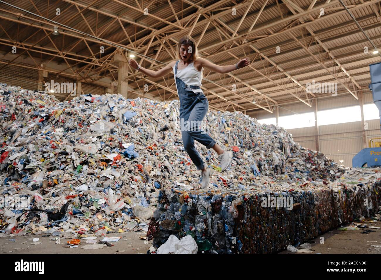 Nature pollution activist at a huge trash dump - Young blonde woman ...