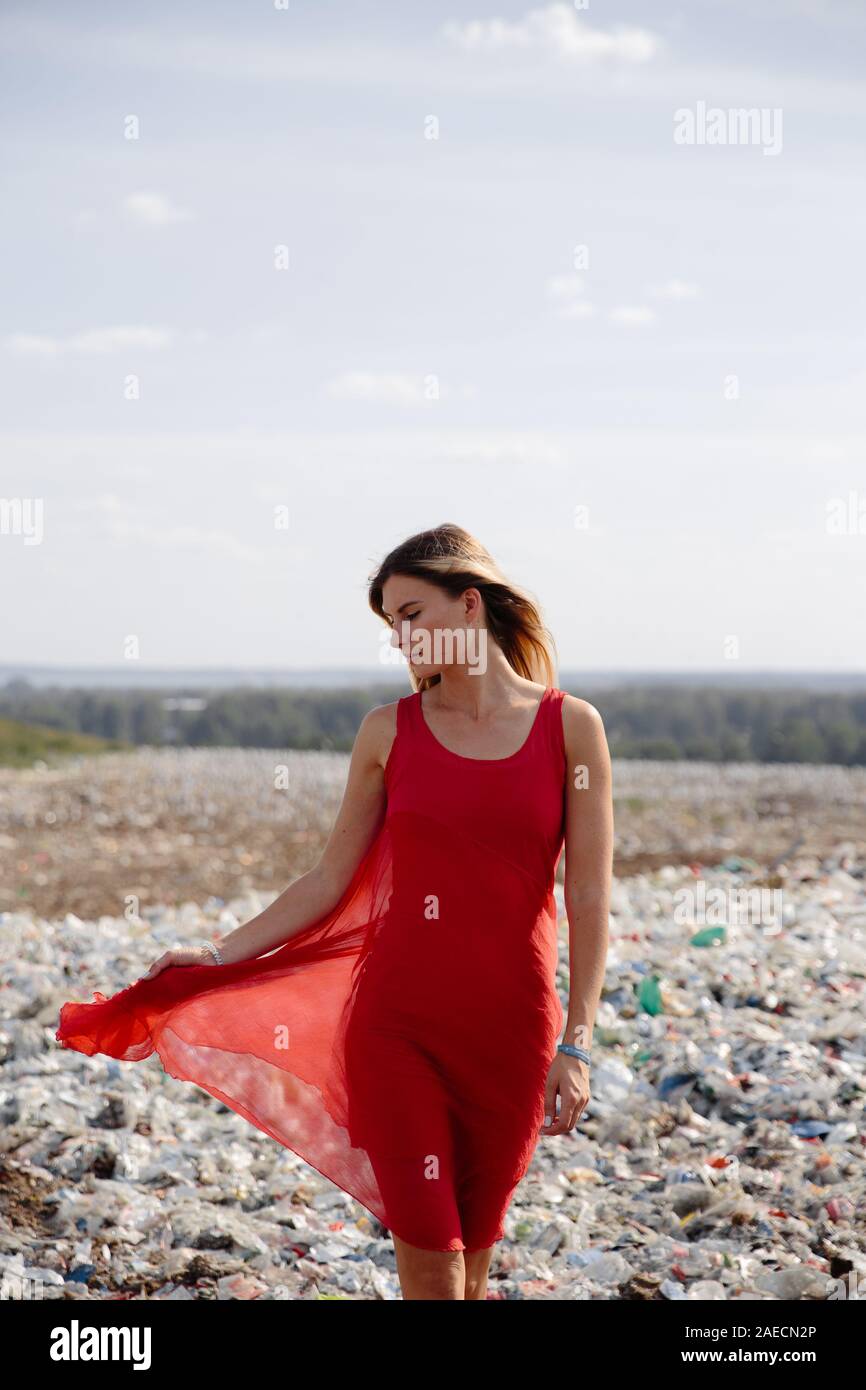 Nature pollution activist at a huge trash dump outdoors - Young blonde ...
