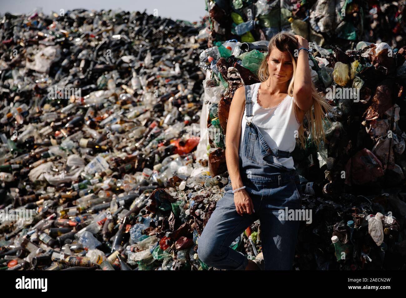 Nature pollution activist at a huge trash dump - Young blonde woman ...