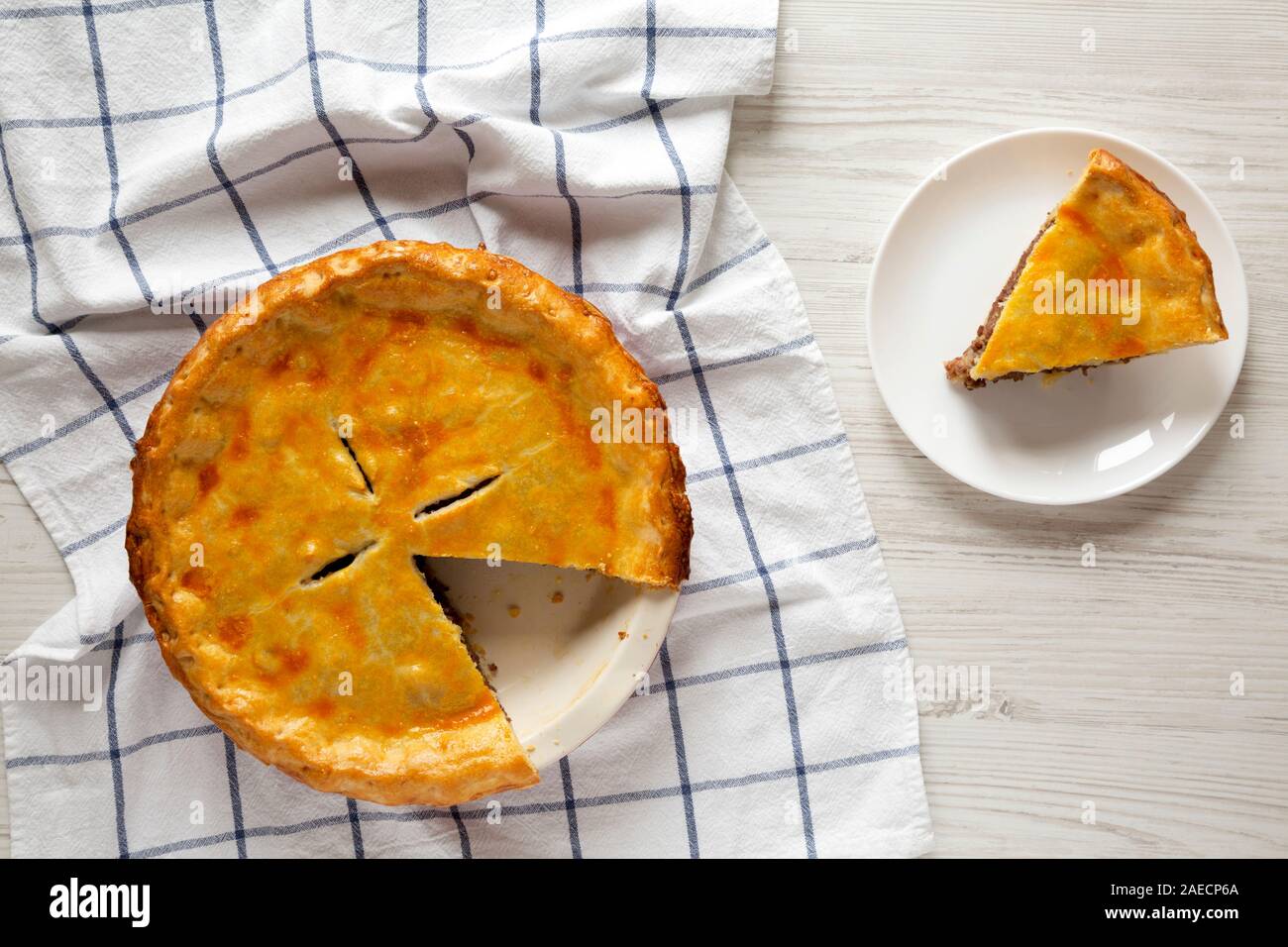 Homemade Canadian Tourtiere(Holiday Meat Pie) on a white wooden surface ...