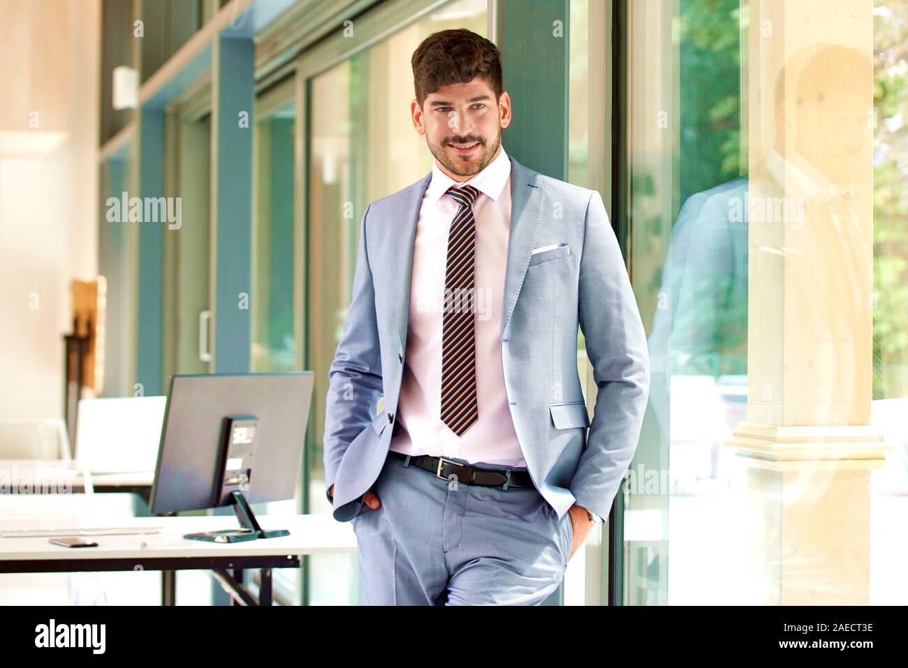 Portrait of confident young businessman wearing suit and tie while ...