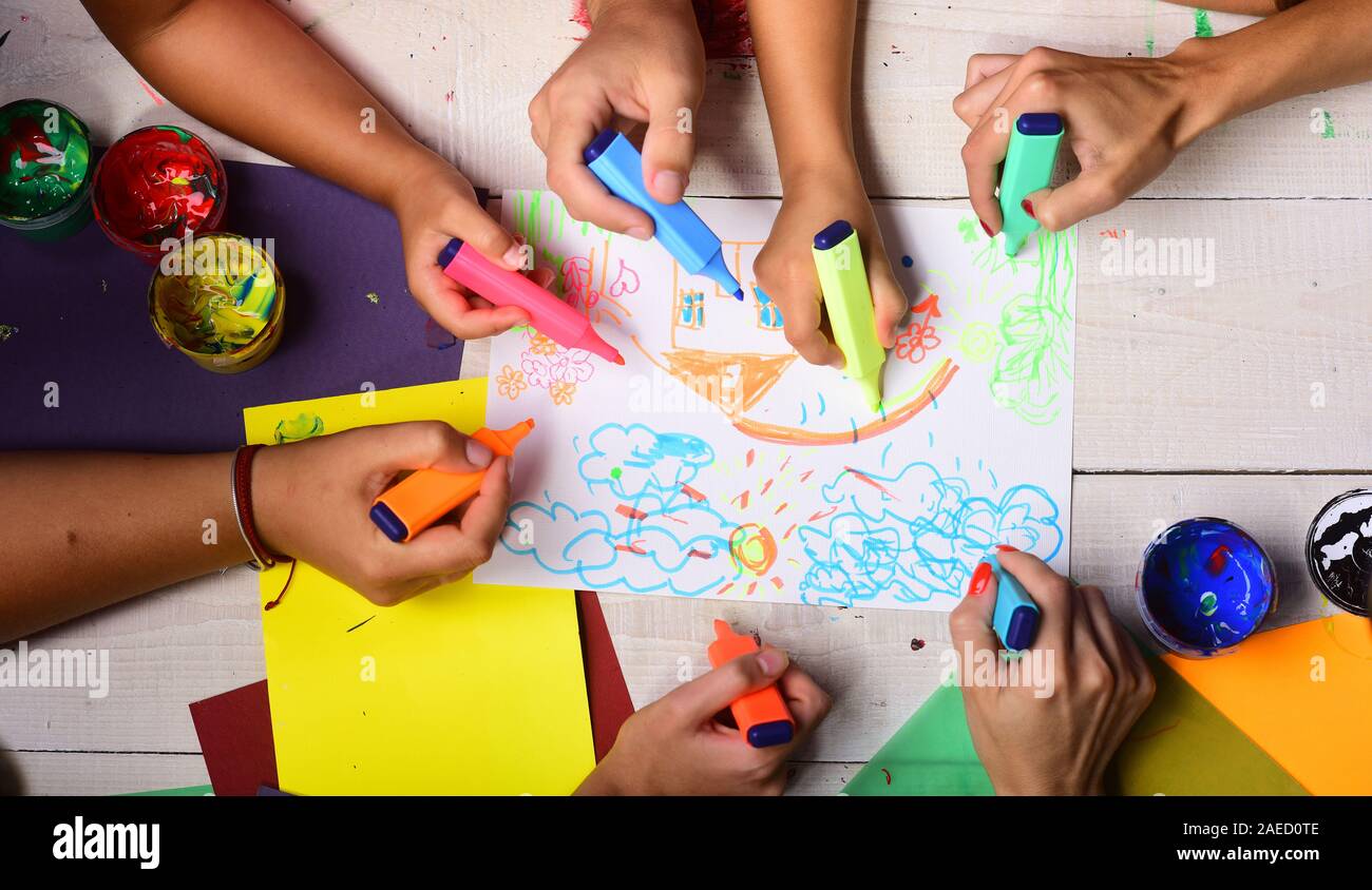 Hands hold colorful markers and draw kids illustration, top view ...