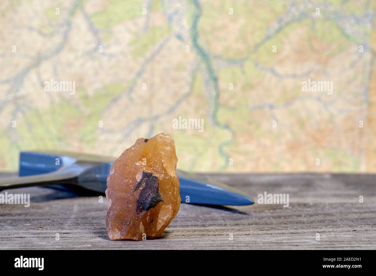 The geologist's hammer and mineral are laid out on a wooden table ...
