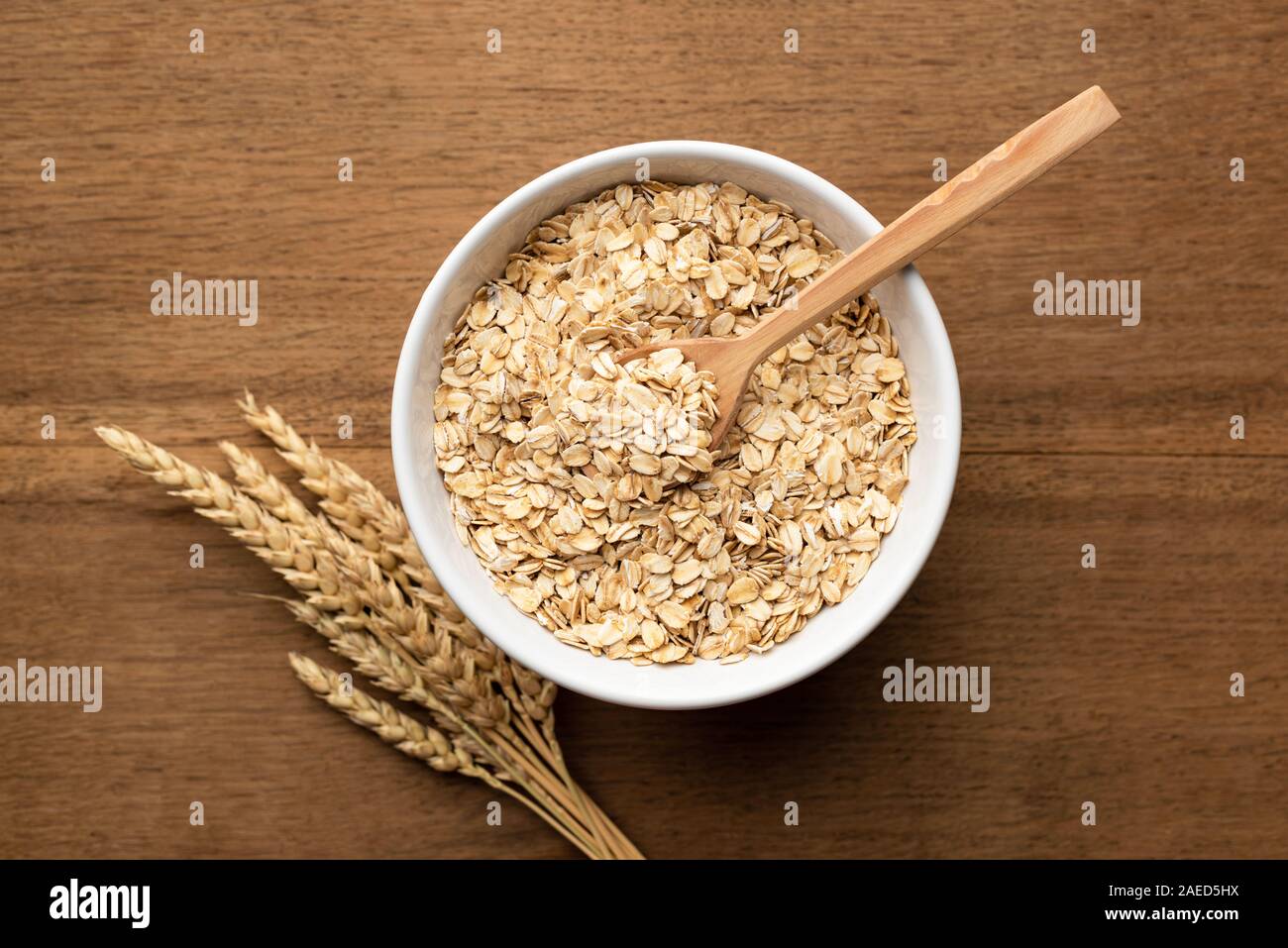 Oat flakes, grains, rolled oats in bowl on wooden table background, top ...