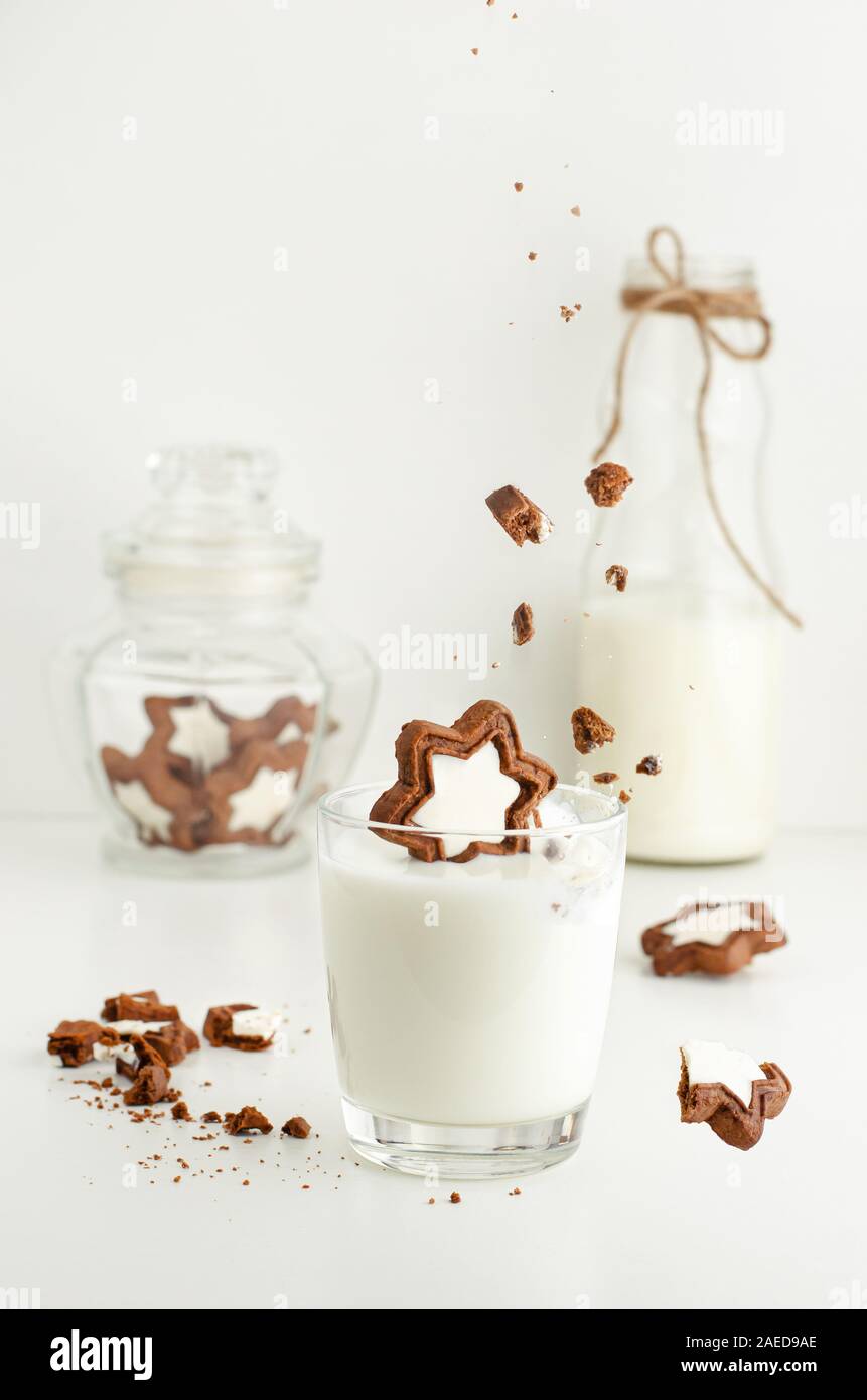 A glass of milk and biscuits in a star shape on white background ...