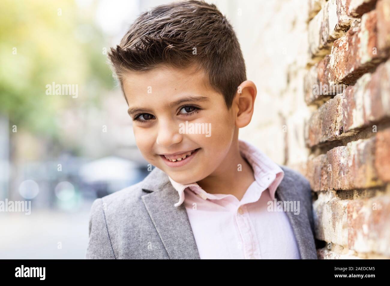 Fashion little kid with a brick wall background Stock Photo - Alamy