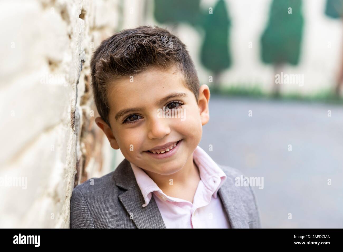 Fashion little kid with a brick wall background Stock Photo - Alamy