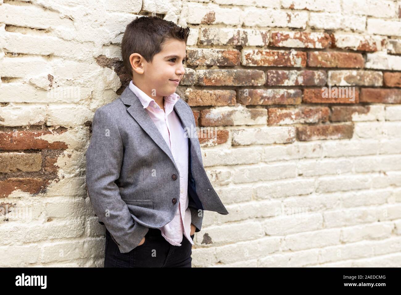 Fashion little kid with a brick wall background Stock Photo - Alamy
