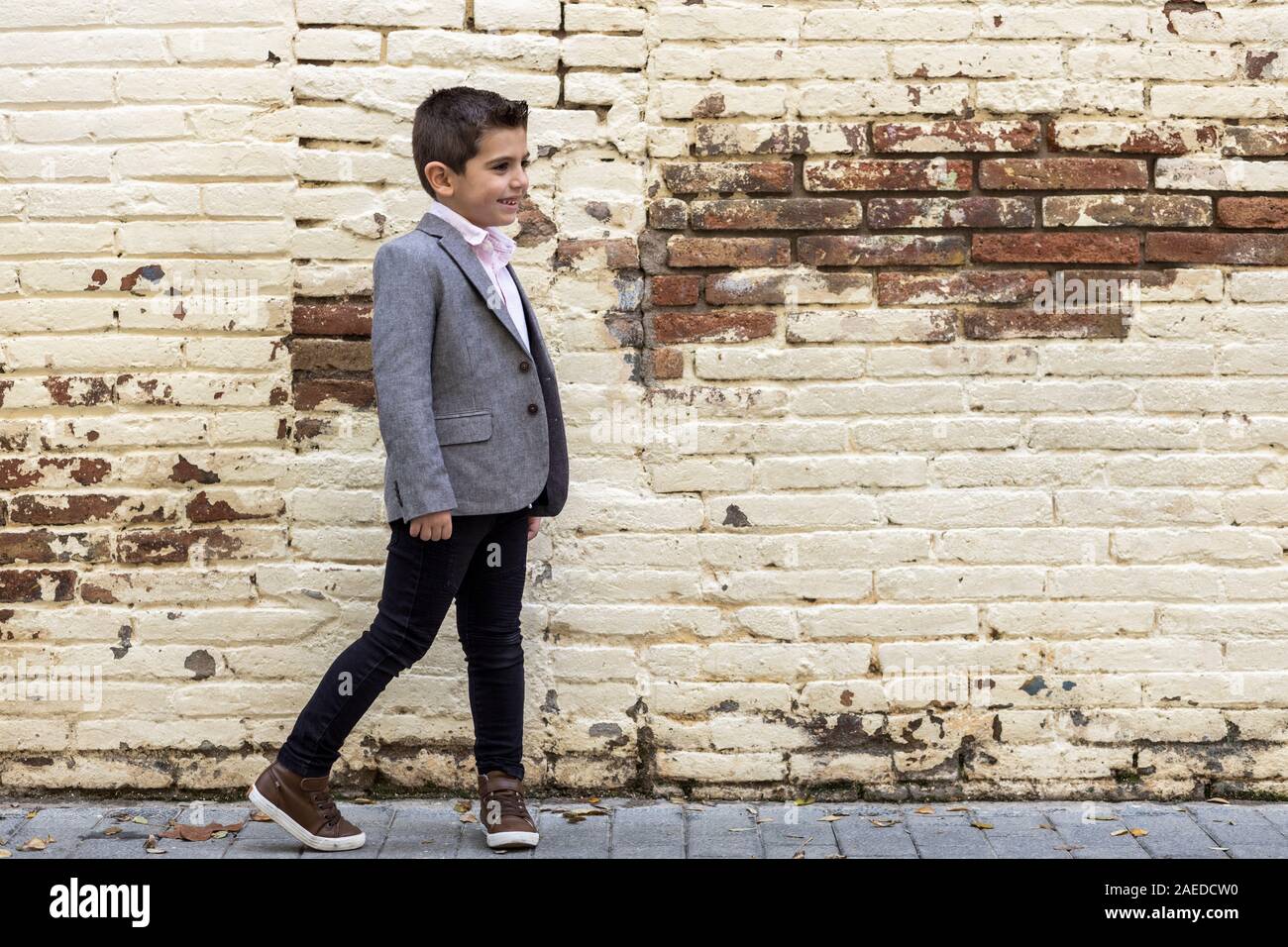 Fashion little kid with a brick wall background Stock Photo - Alamy
