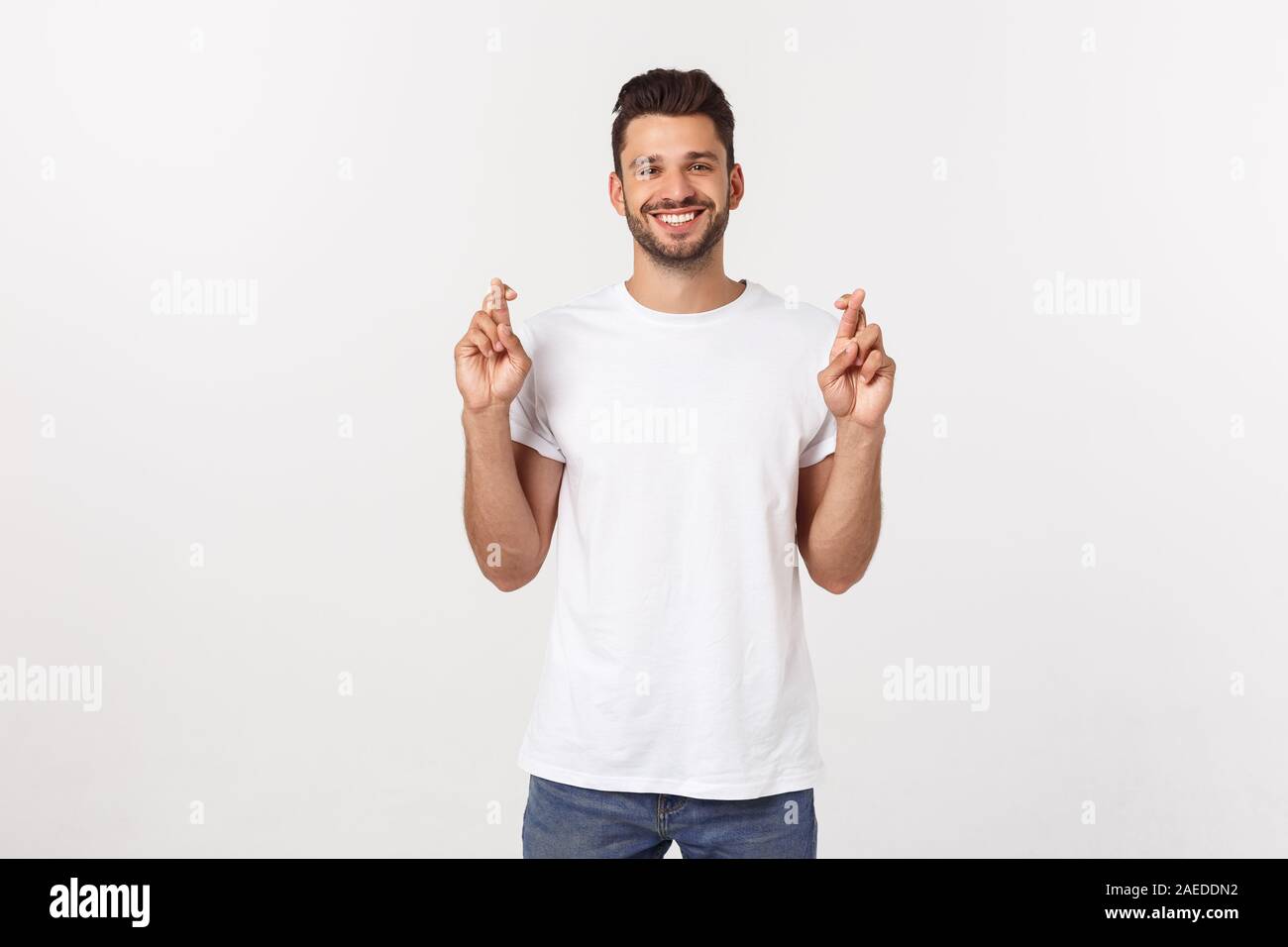Closeup portrait of young handsome man crossing fingers, wishing ...