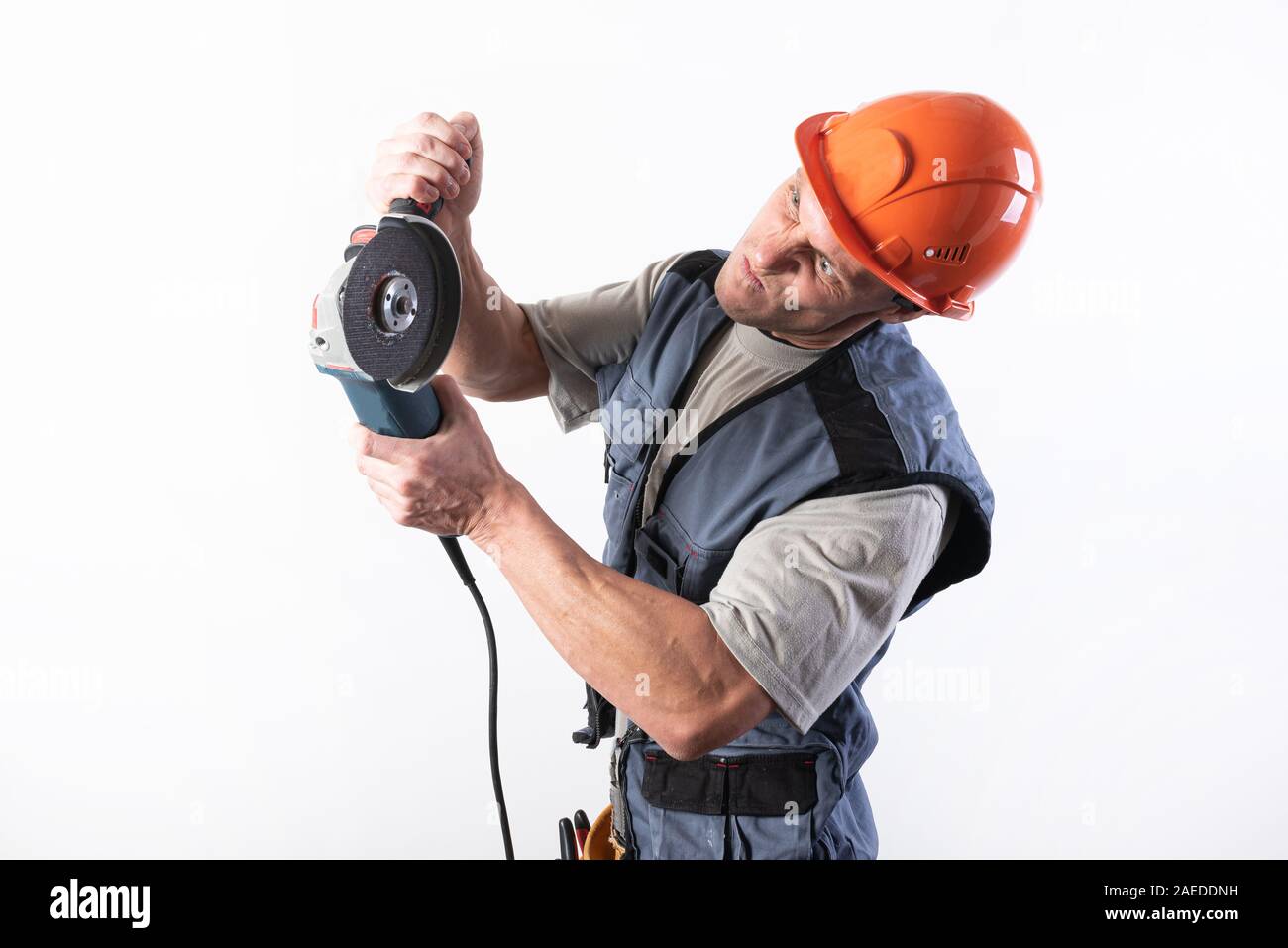Builder with angle grinder, in a helmet, with a funny expression on his ...