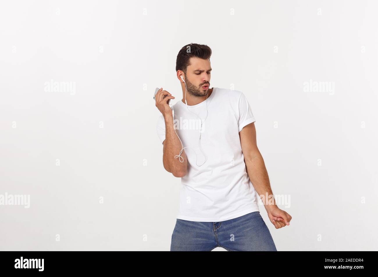 Casual handsome man dancing with mobile phone isolated on white ...