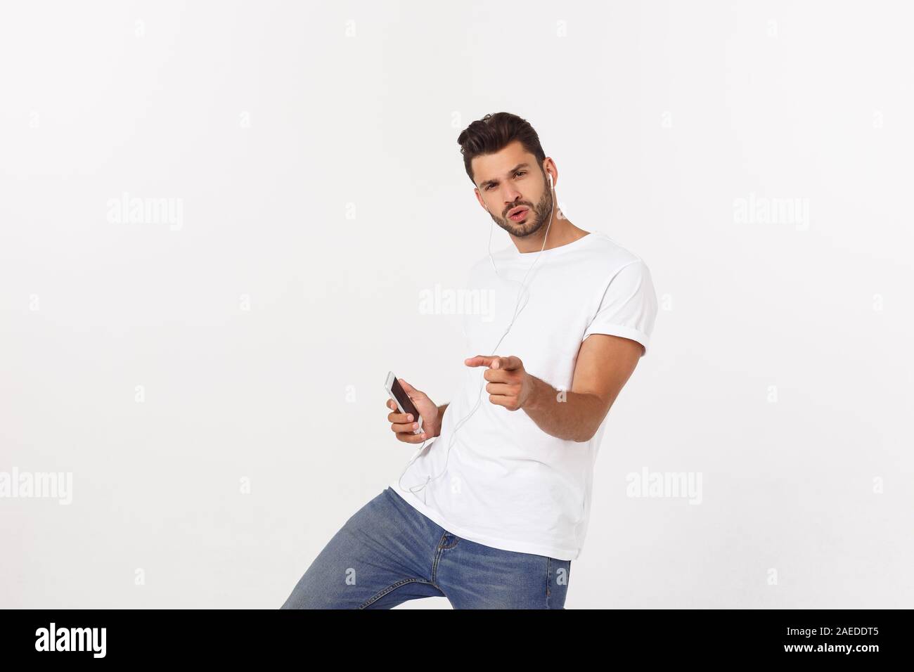Casual handsome man dancing with mobile phone isolated on white ...