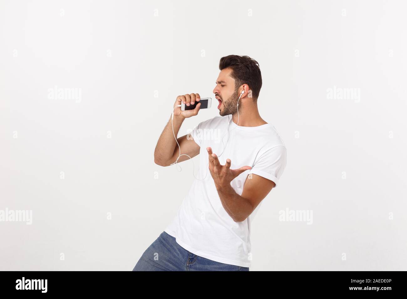 Casual handsome man dancing with mobile phone isolated on white ...