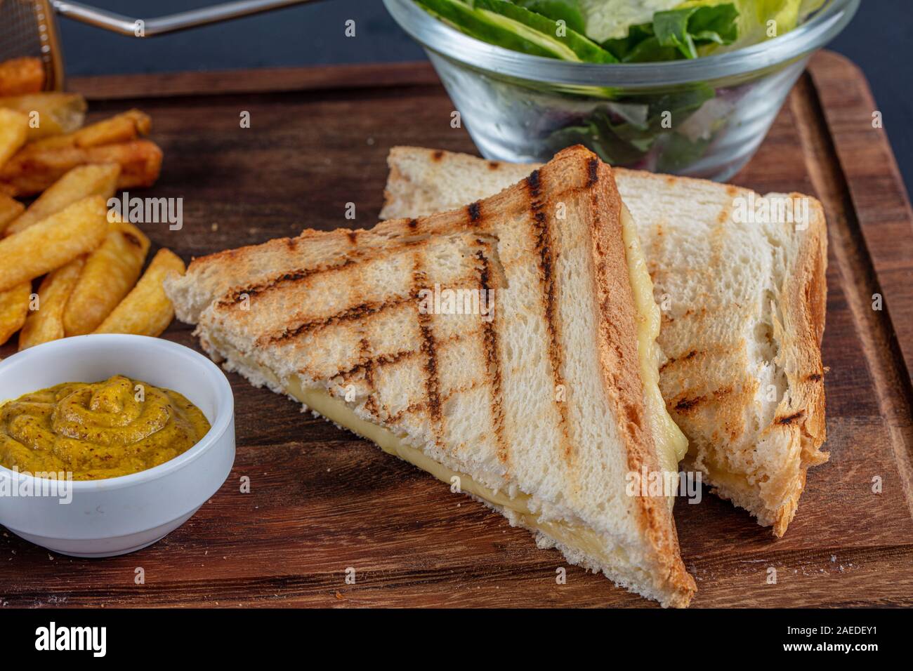 Cheddar Toast served with french fries on cutting board Stock Photo - Alamy