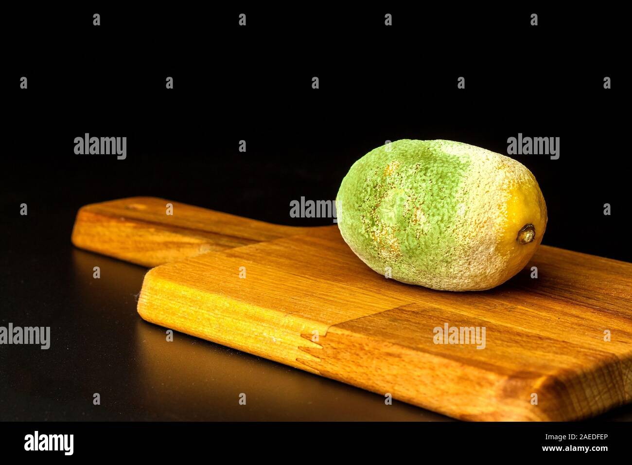 Moldy lemon on a kitchen board. Unhealthy food. Decayed fruit. Moldy ...