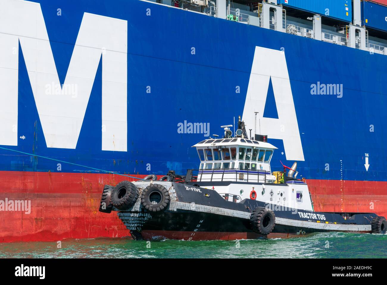 Tugboat assists container ship CMA CGM out of the Port of Oakland under ...