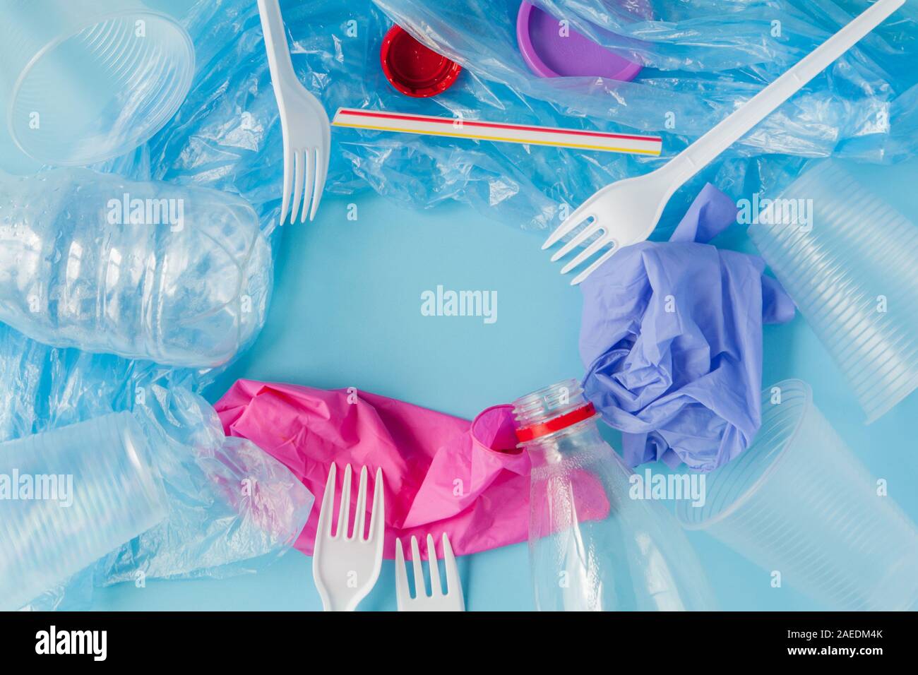 Top view of various kinds of disposable plastic waste on blue ...