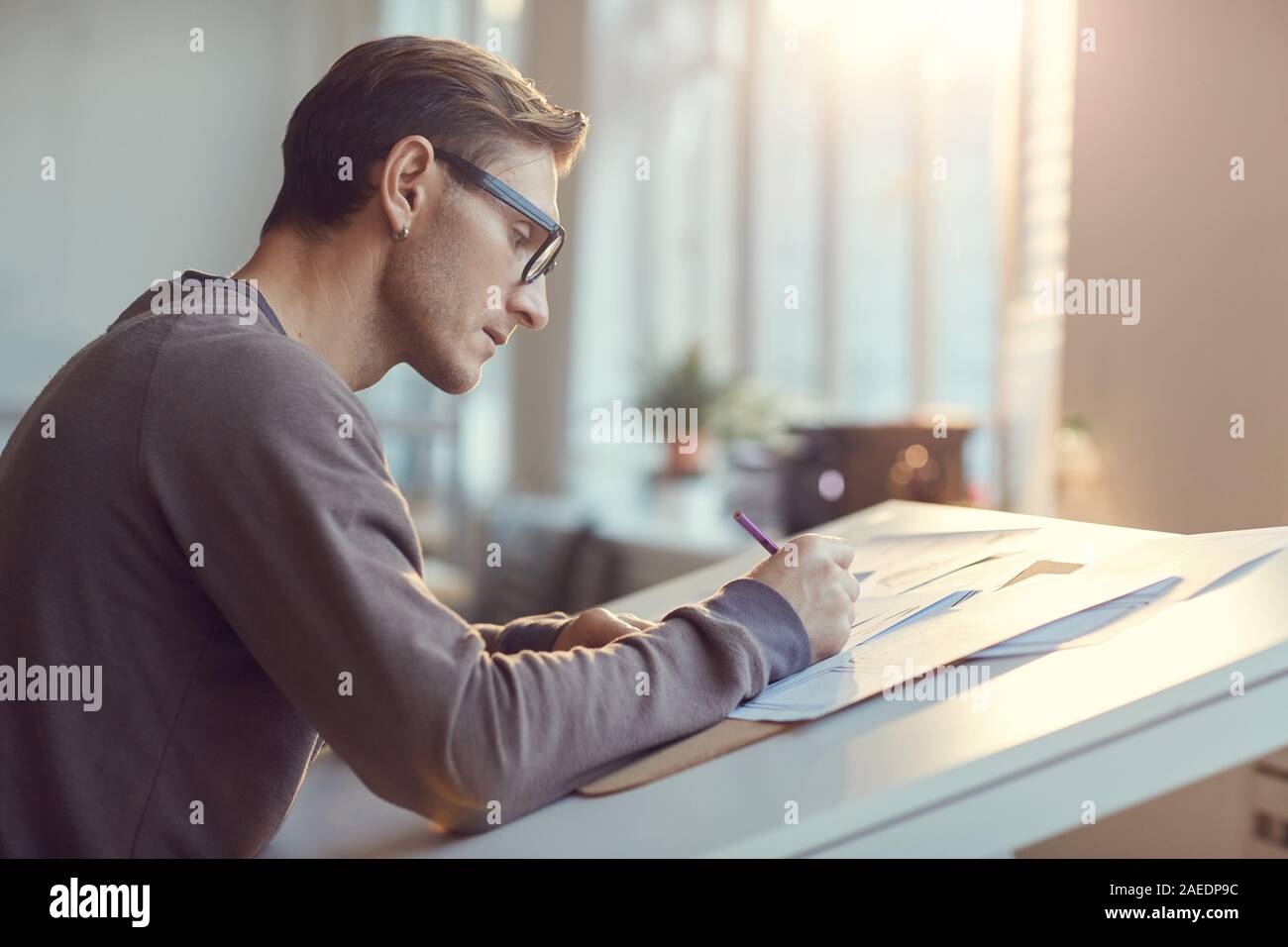 Side view portrait of contemporary artist of architect working on ...