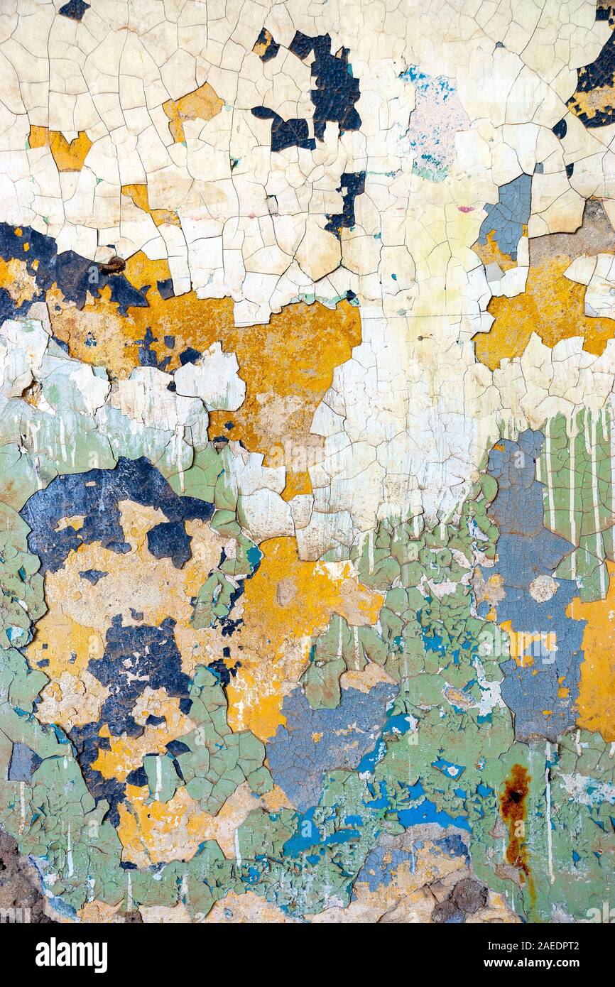 Very old damaged cracked wall with many different layers of paint ...