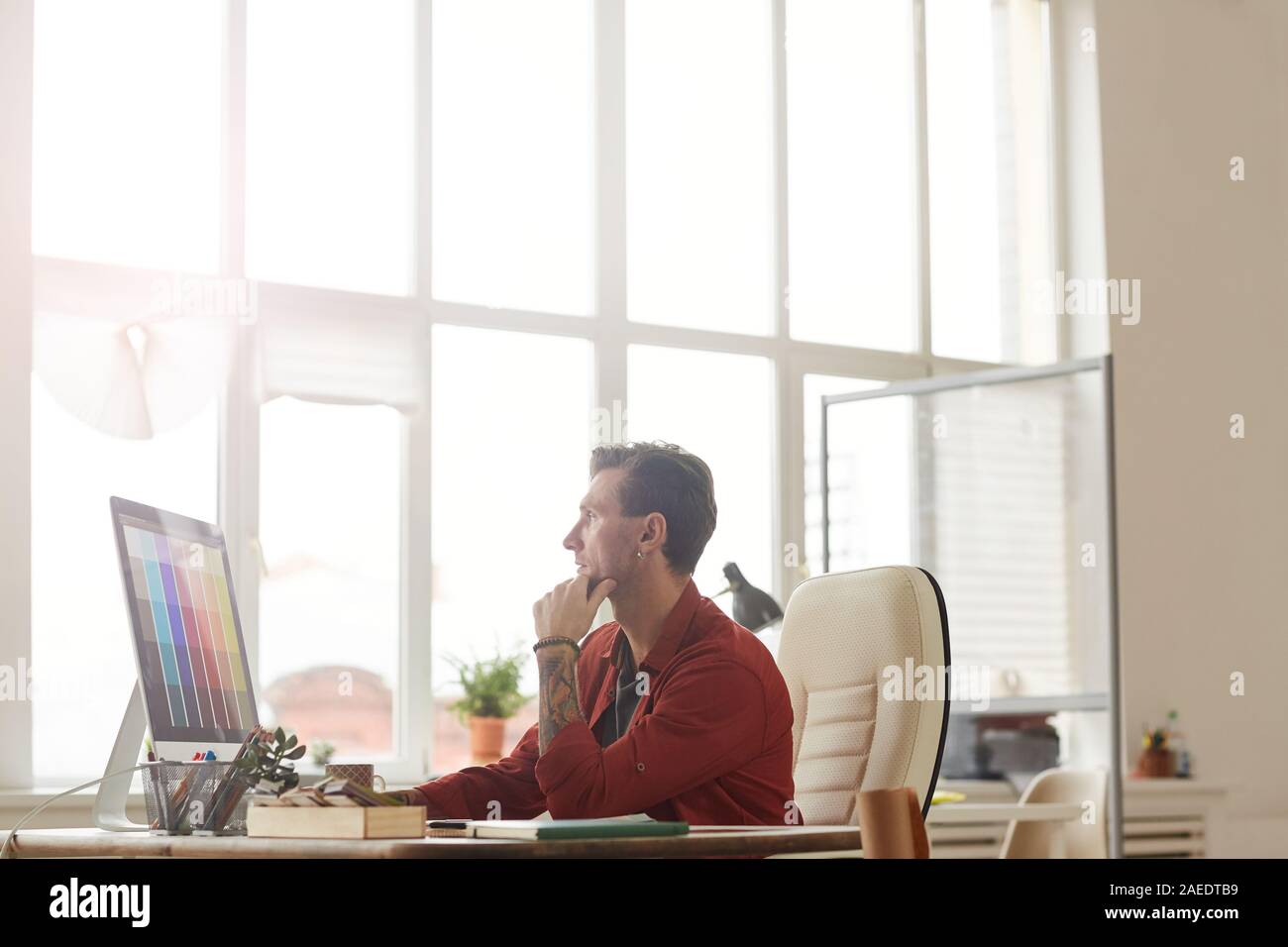 Side view portrait of pensive male designer choosing color palette ...