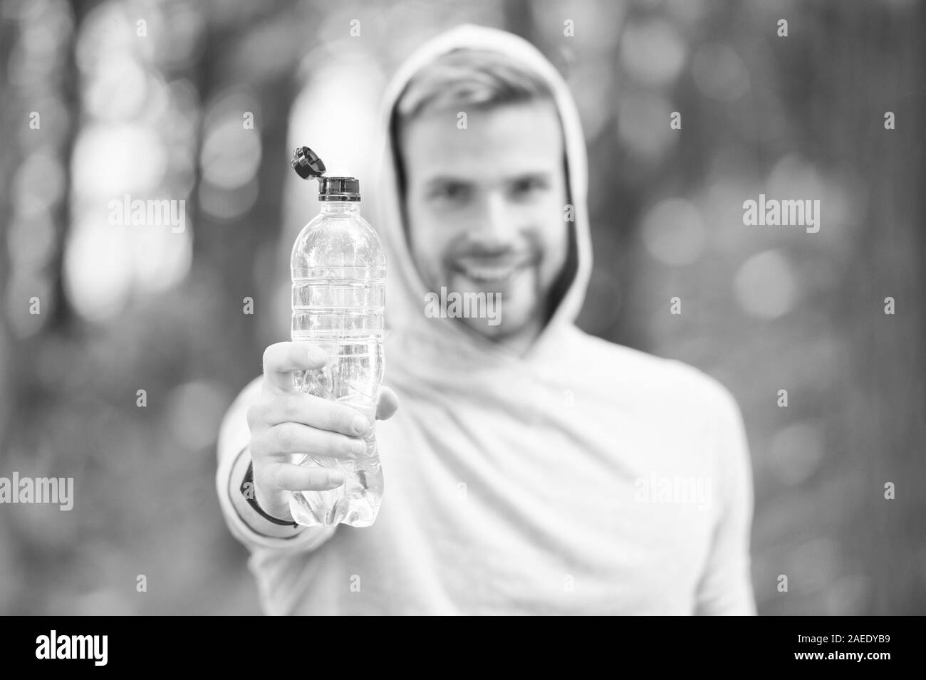 Stay hydrated. Man athletic sportsman hold bottle water. Man athlete ...