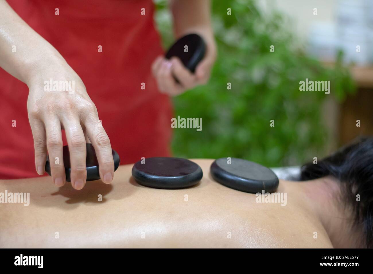 Spa Hot Stone Massage, putting on back Stock Photo - Alamy