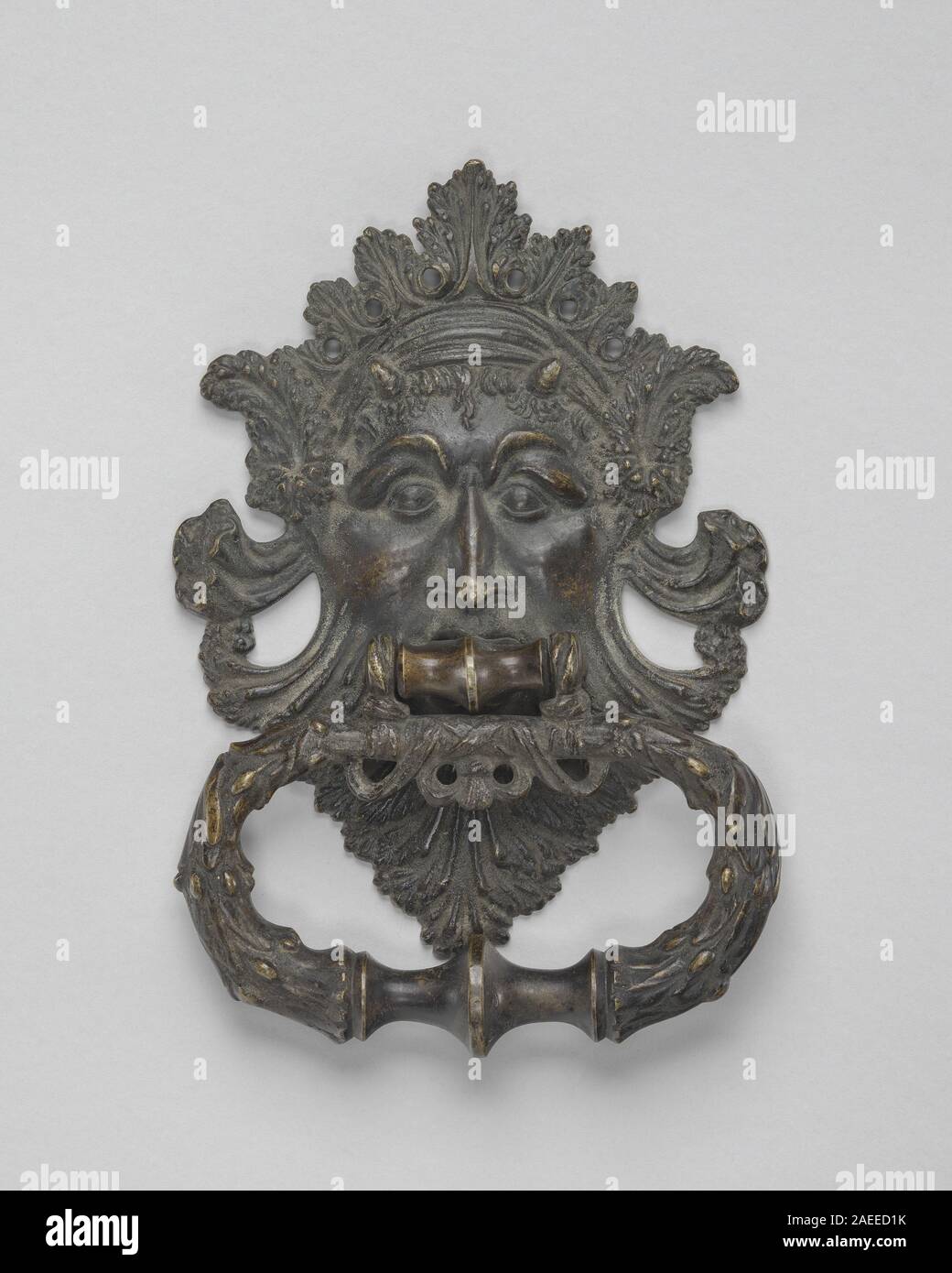 A 16th-century Italian door knocker made of metal, featuring decorative ...