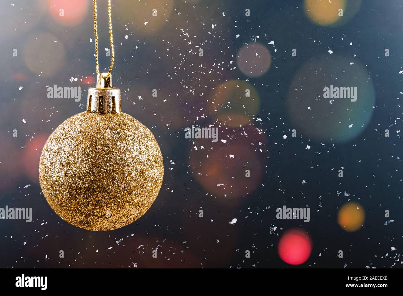 Red shiny ball on a dark background with flying snow and lights Stock ...