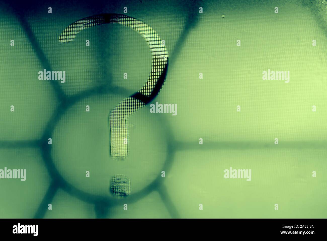 Question mark written on the misted glass of a window closed by a bars ...