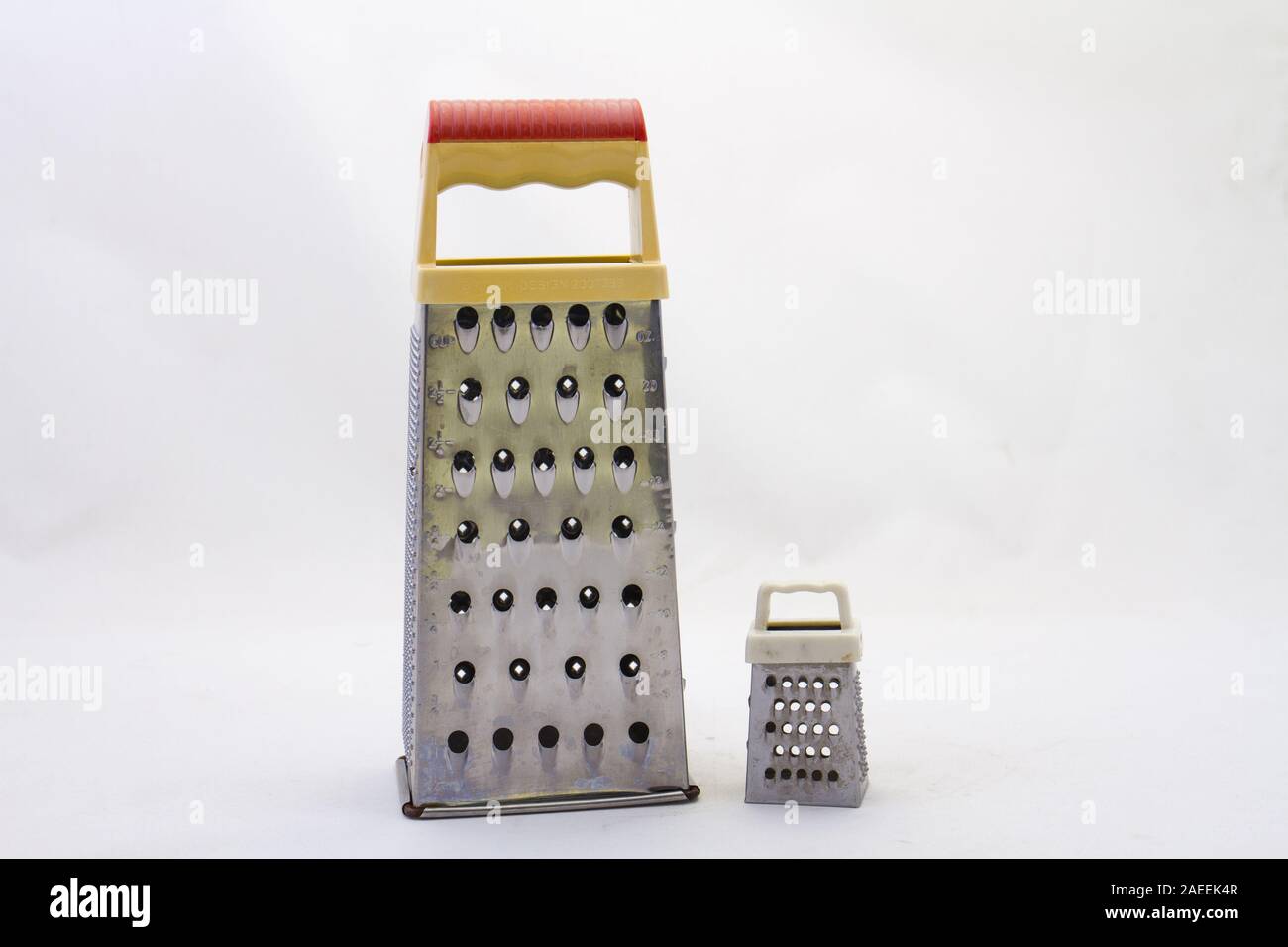 A large grater and a small grater isolated on a clear surface image in ...