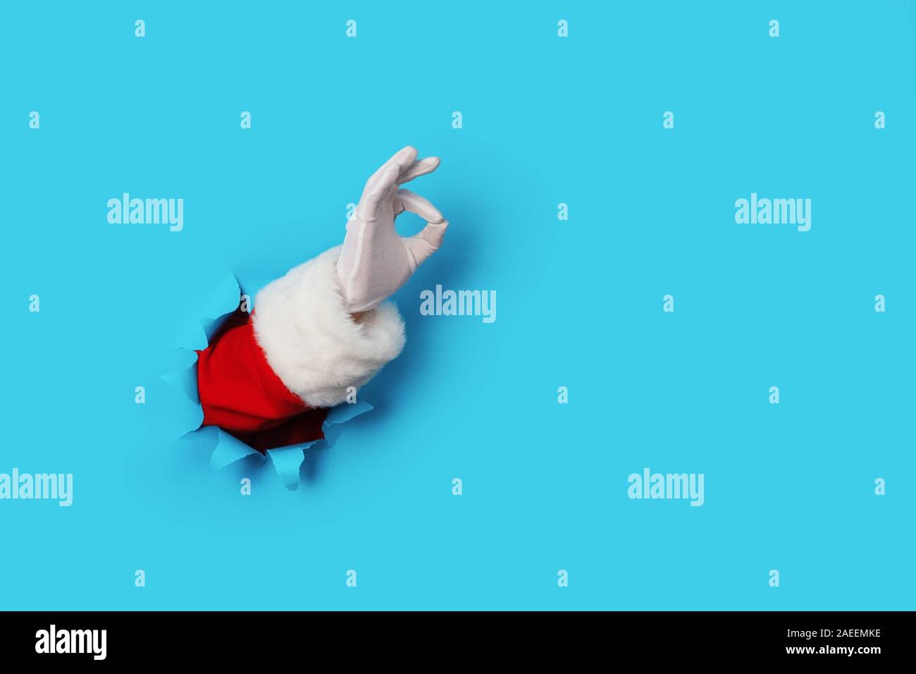 Santa Claus hand showing OK isolated on light blue Stock Photo - Alamy