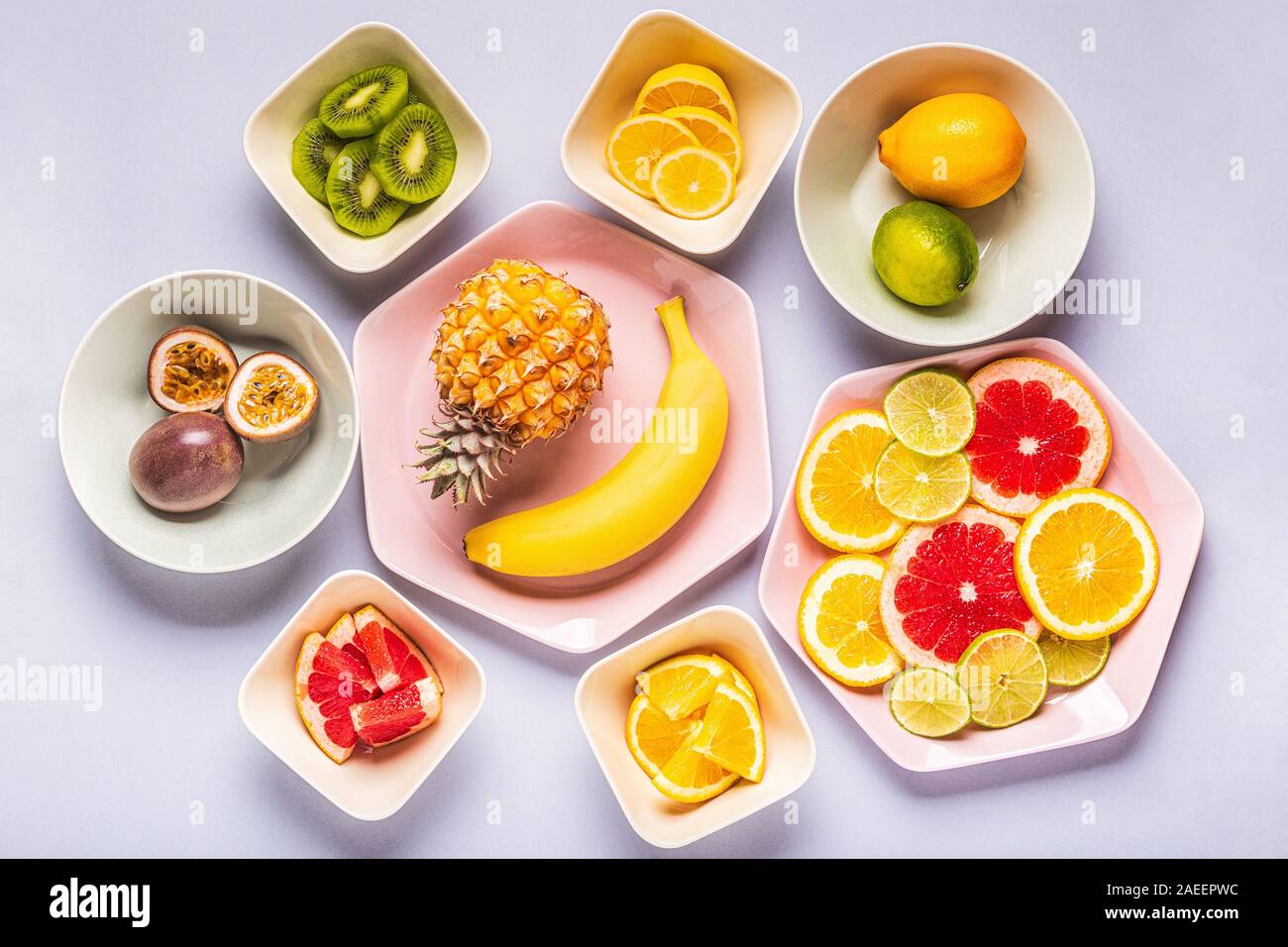 Tropical fruits whole and slices on plates, top view Stock Photo - Alamy