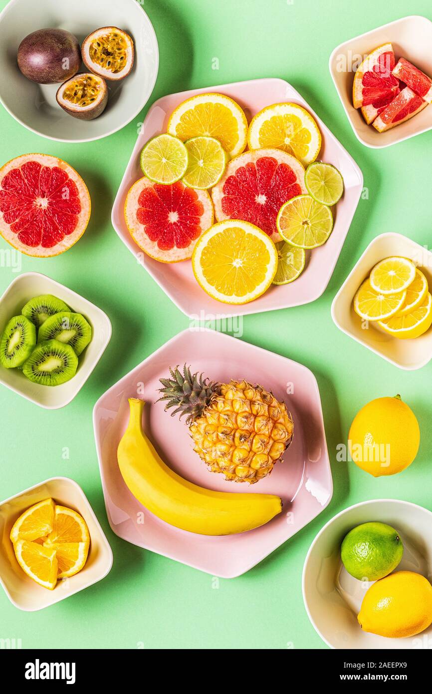 Tropical fruits whole and slices on plates, top view Stock Photo - Alamy