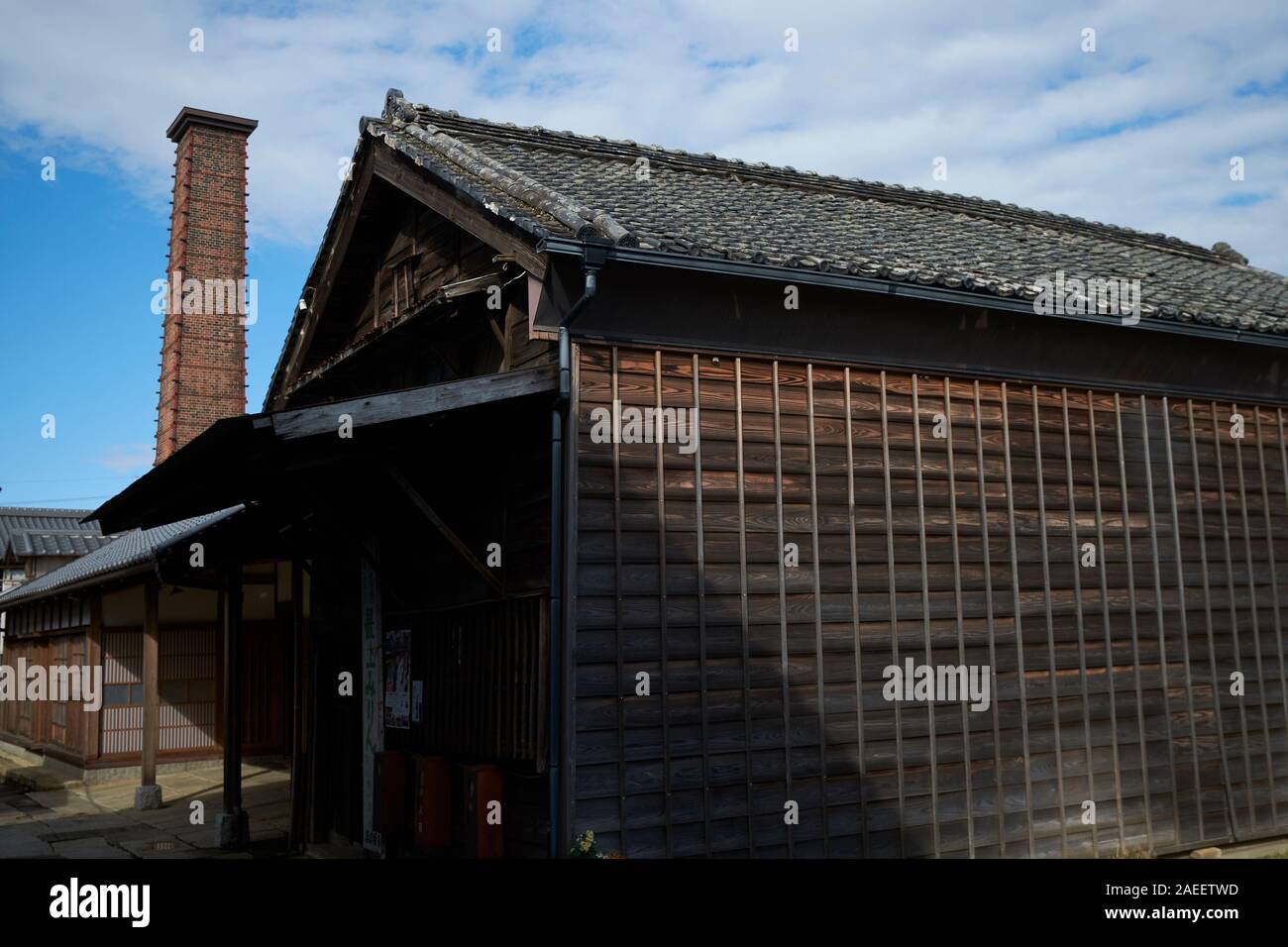 Brick smokestack and old wood building at the Tokun sake brewery in the ...