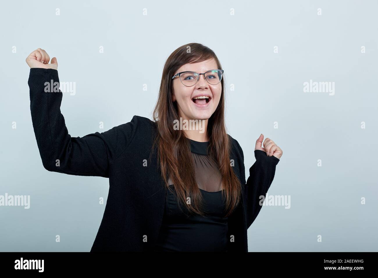 Pretty young celebrating a victory in winner position, keeping hands ...
