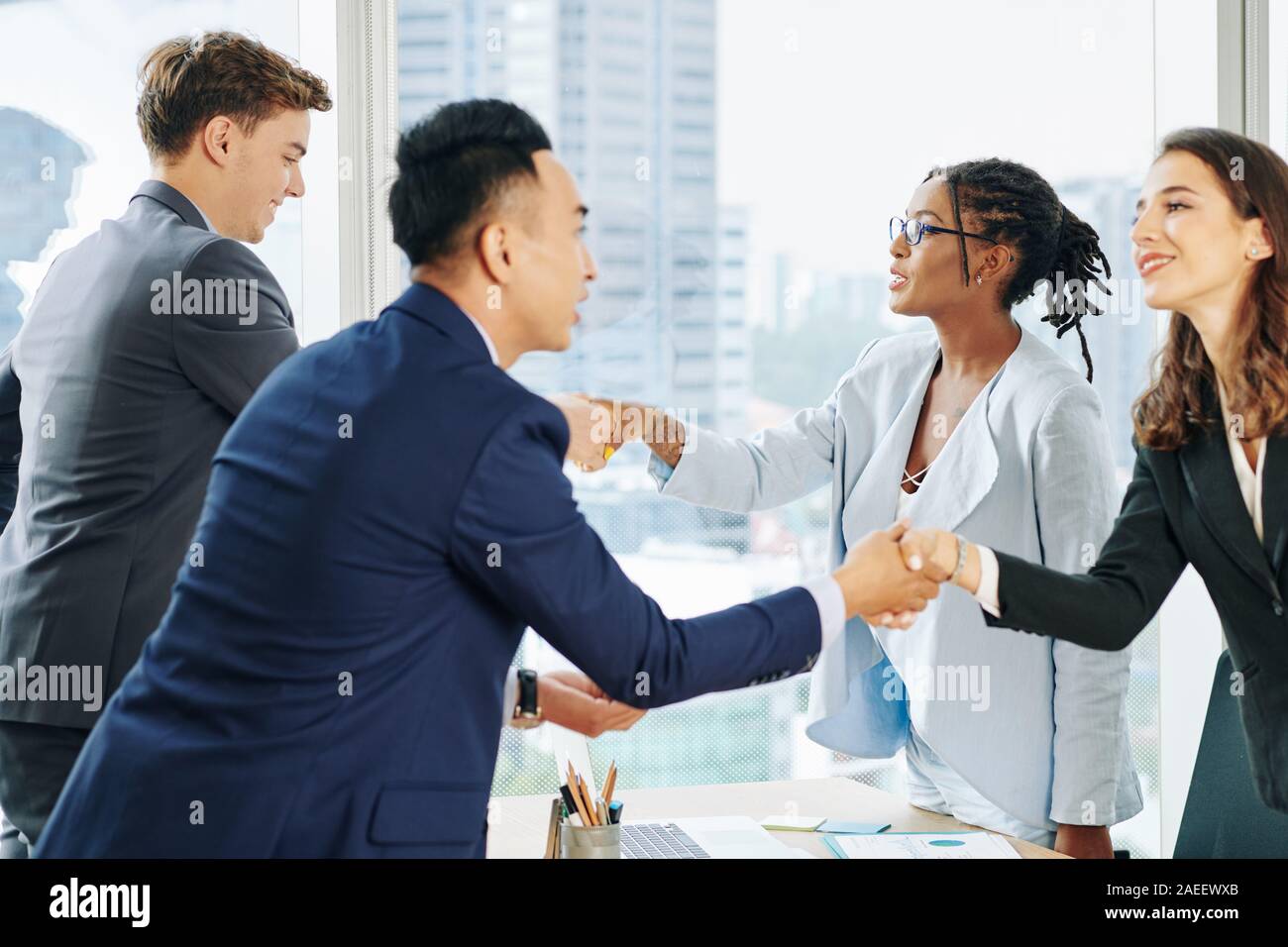 Smiling polite business people shaking hands and greeting each other ...