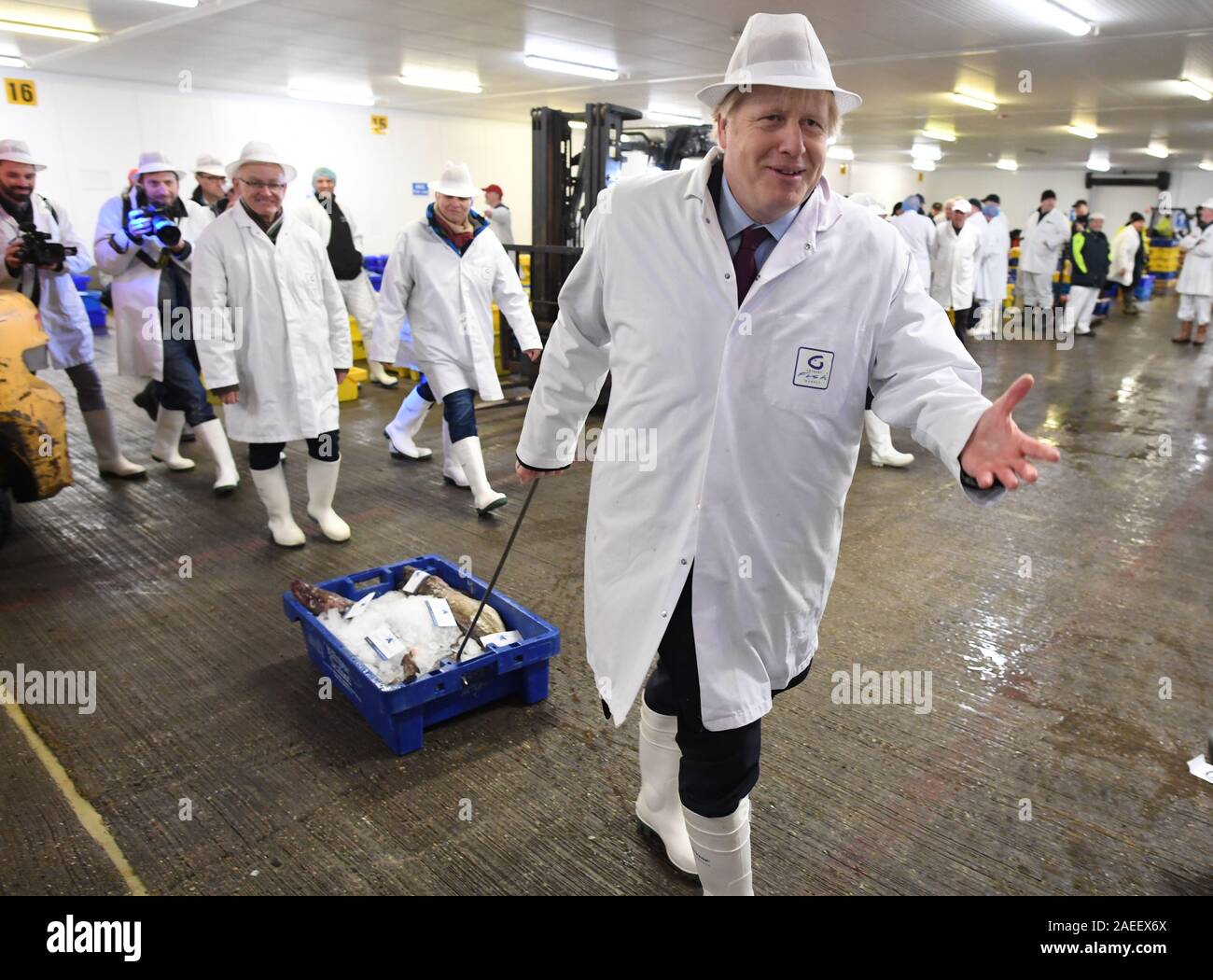 Prime Minister Boris Johnson drags a crate of fish during a visit to ...