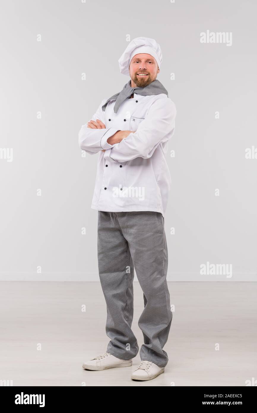 Successful young male chef with his arms crossed by chest looking at ...