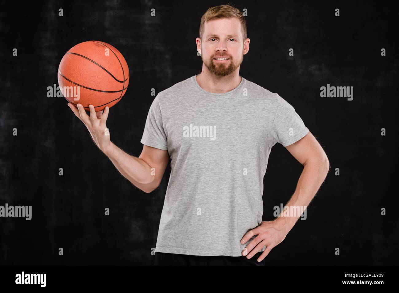 Professional male basketball trainer or player with ball standing in ...