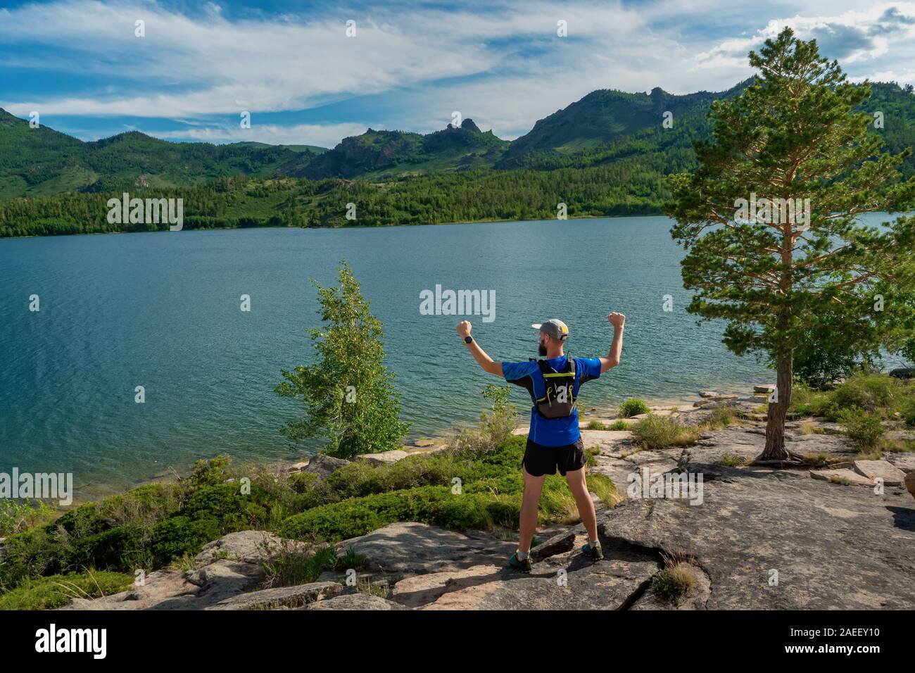 Athlete runner standing on the edge of a cliff overlooking a beautiful ...