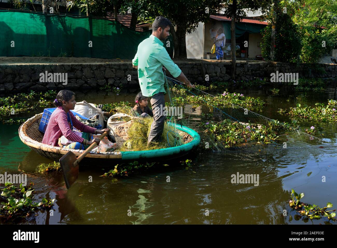 Family fishing in paddle bamboo coracle boat, backwaters, Kumarakom ...