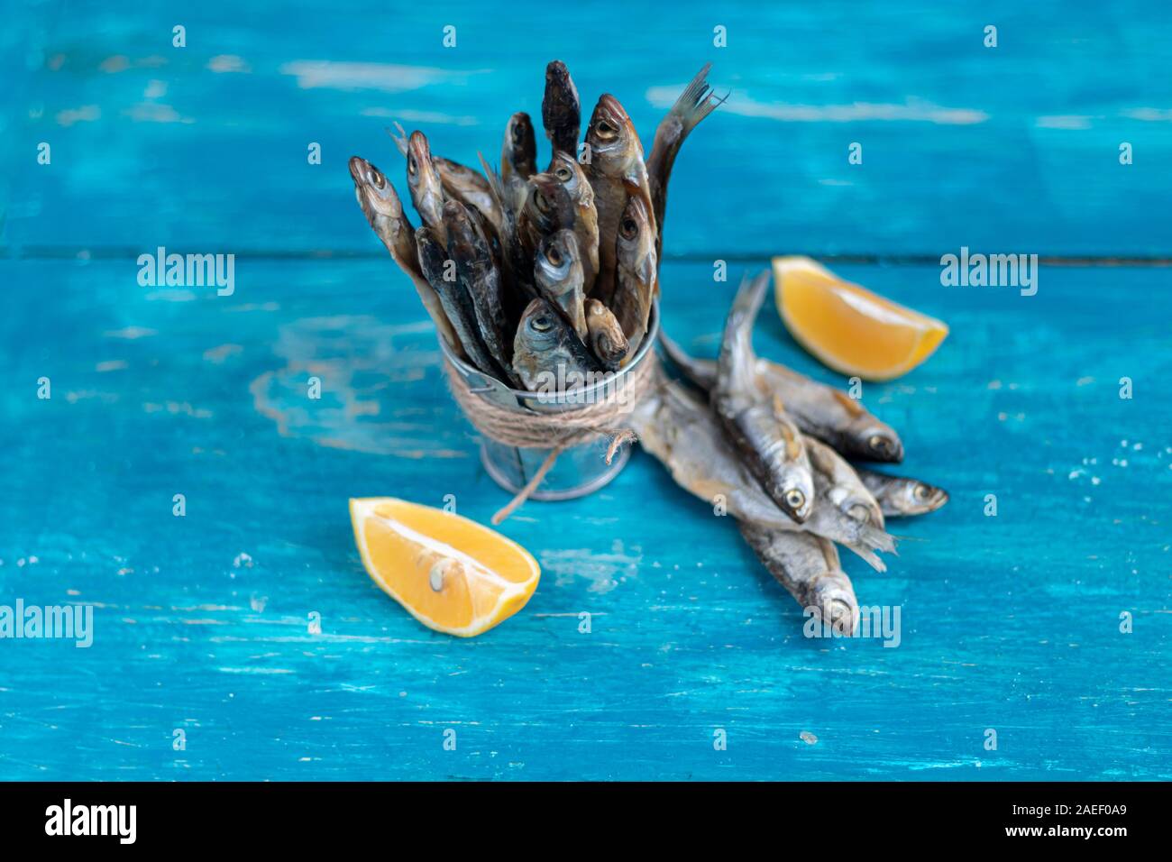 Small, salted fish. Near the slices of lemon. Good snack for beer. Sea ...