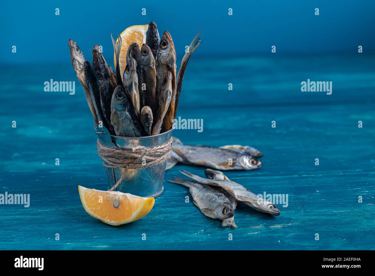 Small, salted fish. Near the slices of lemon. Good snack for beer. Sea ...