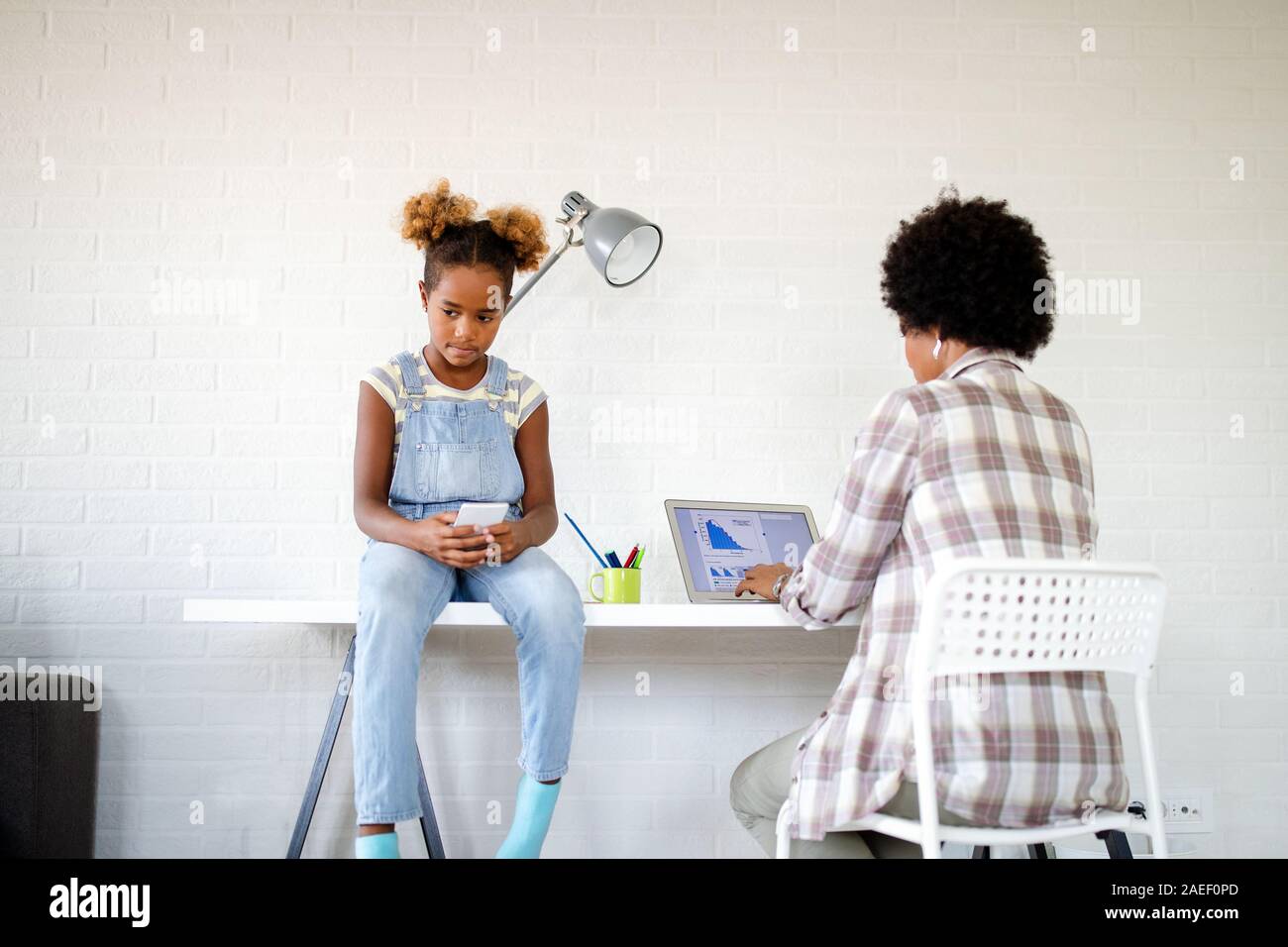 Frustrated sad child looking for attention from busy working parents ...