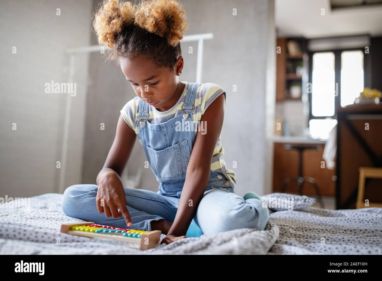 Happy african american kid girl learn to count at home with abacus ...