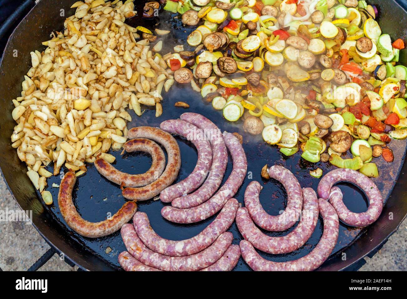 A huge frying pan with a variety of food such as fried sausages and ...